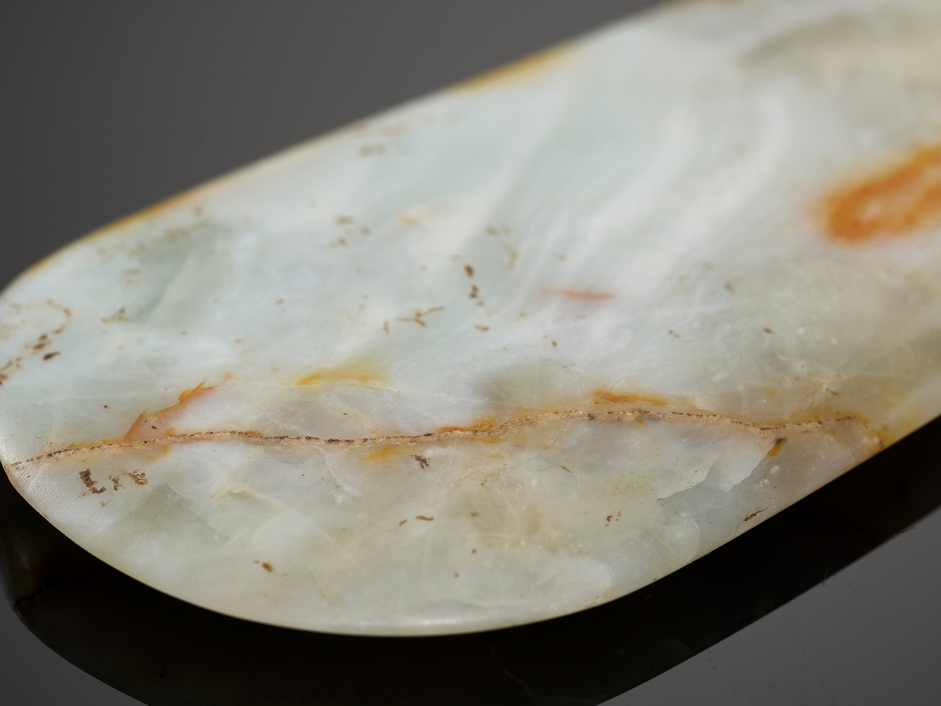 Lot 142 - A CELADON AND RUSSET JADE AXE, NEOLITHIC