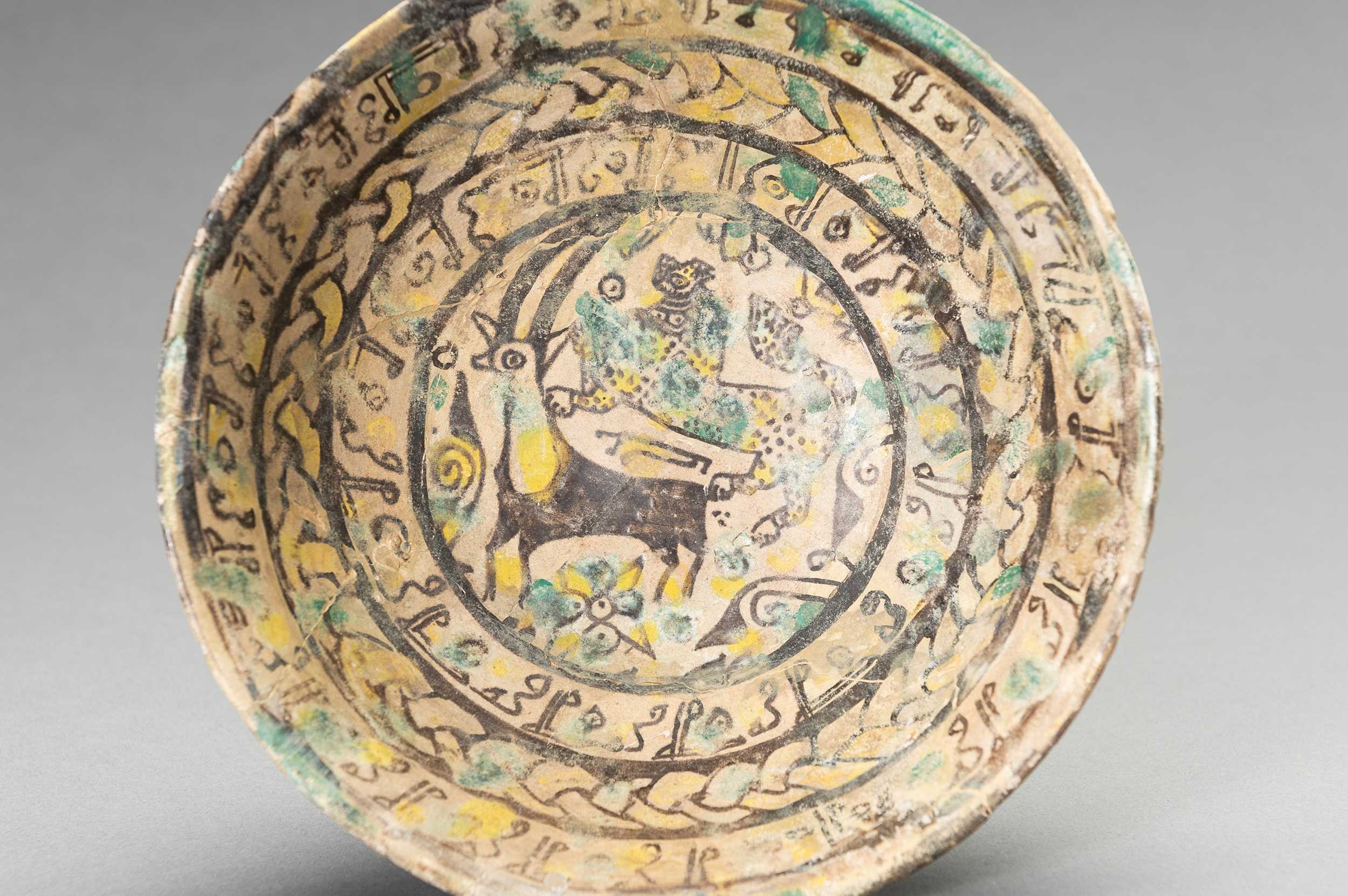 Lot 1377 - A NISHAPUR ‘IBEX AND BEAST’ POTTERY BOWL,