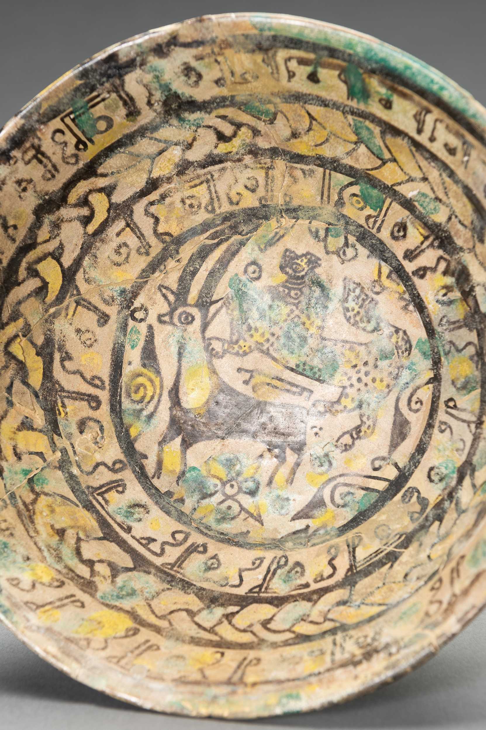 Lot 1377 - A NISHAPUR ‘IBEX AND BEAST’ POTTERY BOWL,